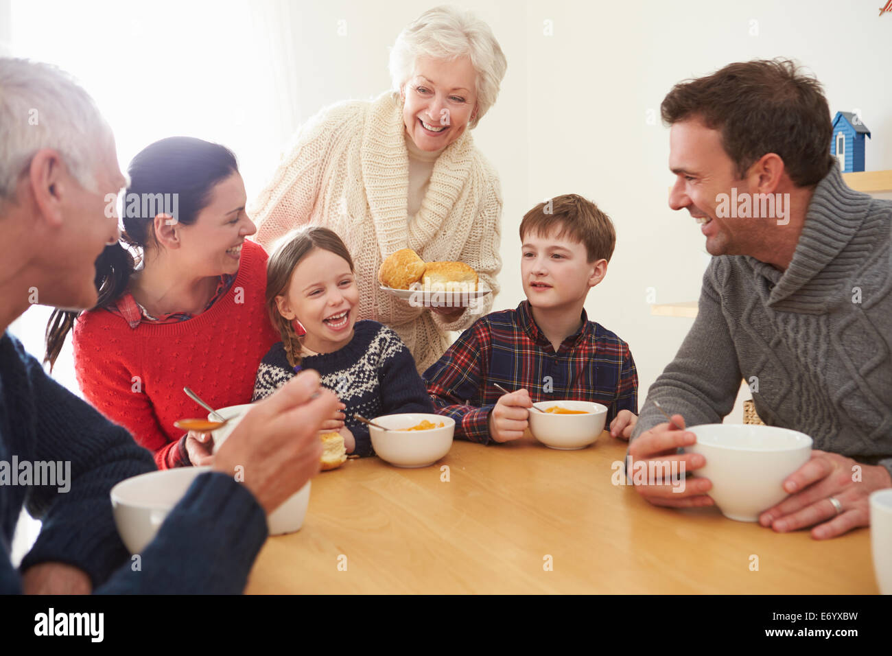 Multi Generation Family Eating Lunch At Kitchen Table Stock Photo - Alamy