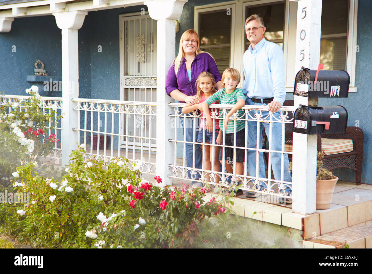 Portrait Of Family Standing On Porch Of Suburban Home Stock Photo - Alamy