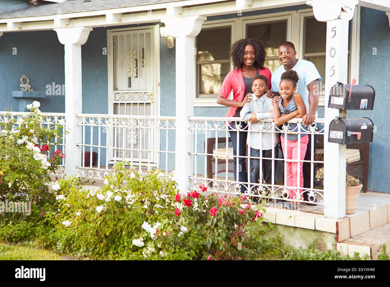 Portrait Of Family Standing On Porch Of Suburban Home Stock Photo - Alamy