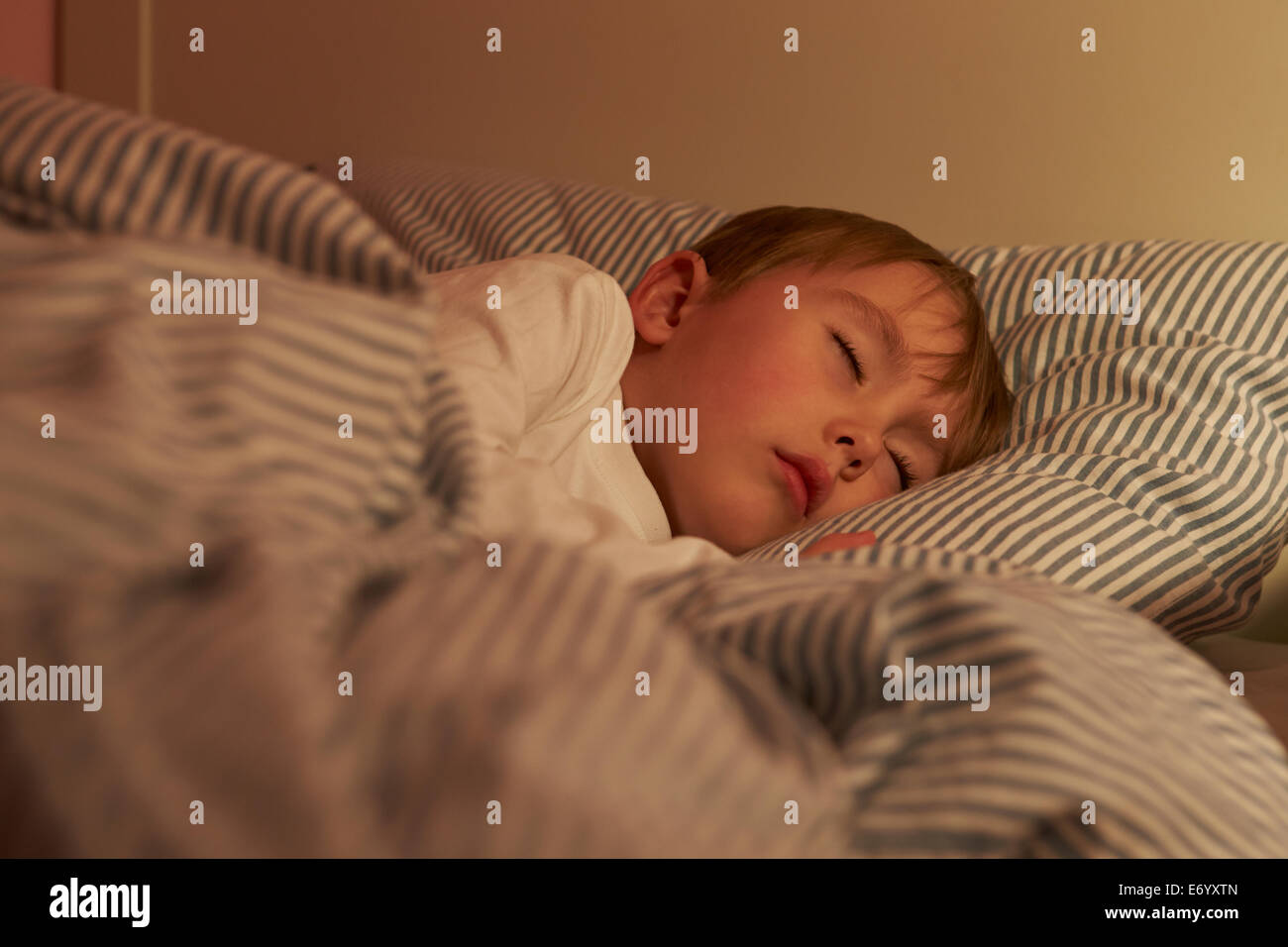 Young Boy Asleep In Bed At Night Stock Photo - Alamy