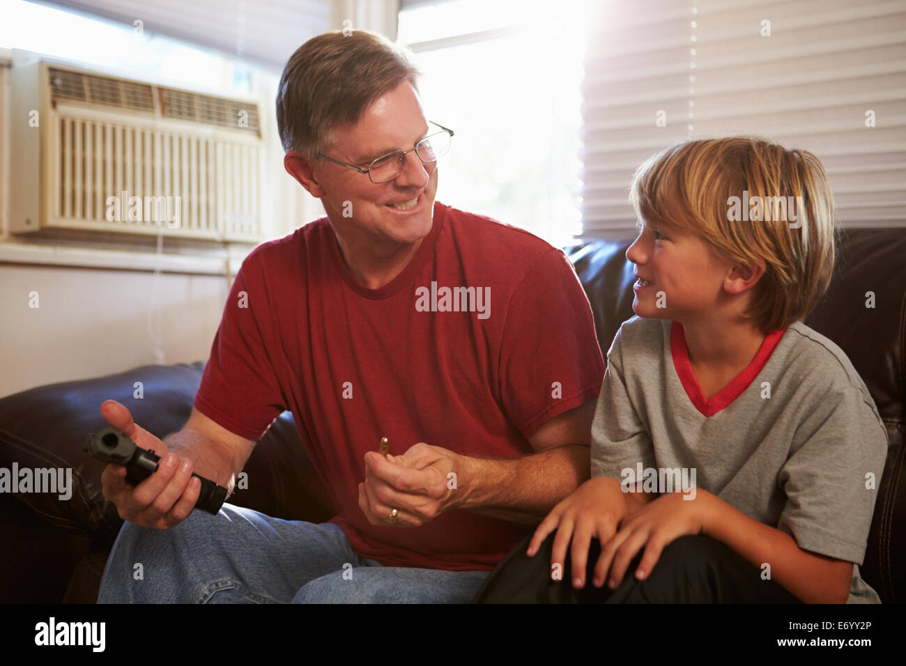Father Showing Son How To Use Gun At Home Stock Photo - Alamy
