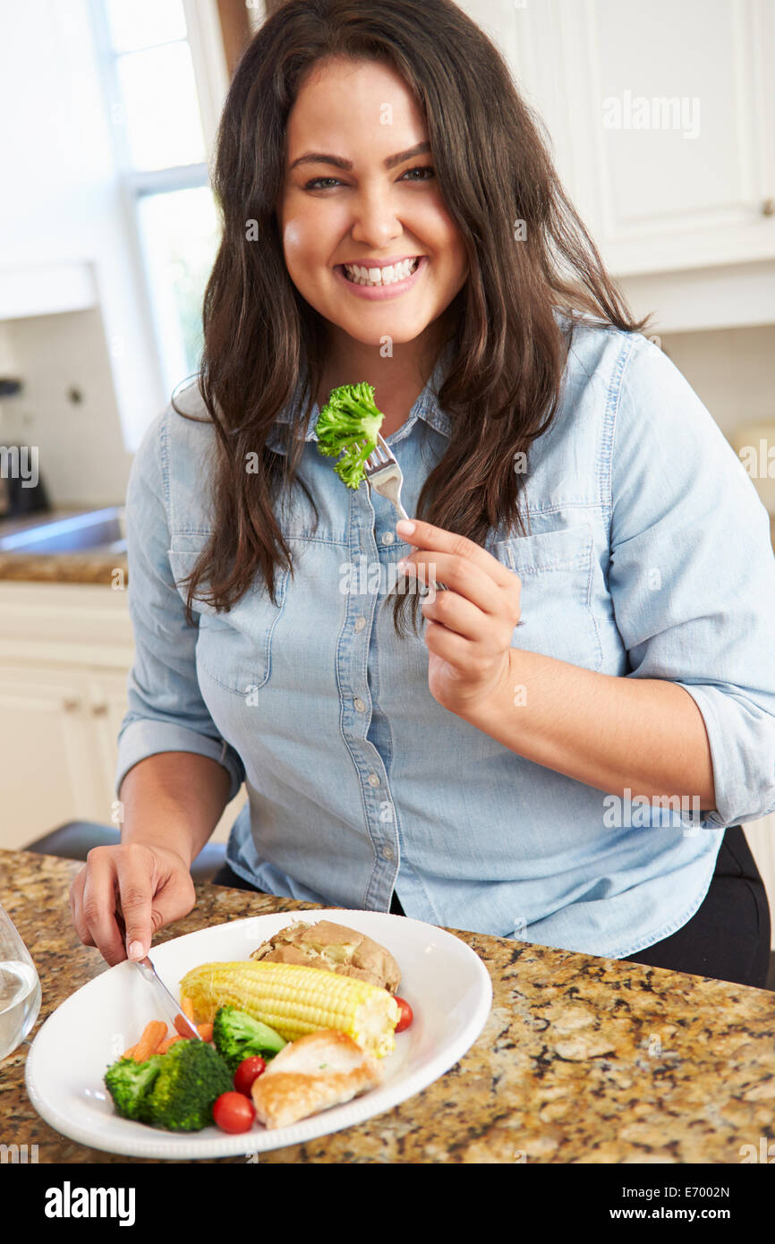 Overweight Woman Eating Healthy Meal In Kitchen Stock Photo - Alamy