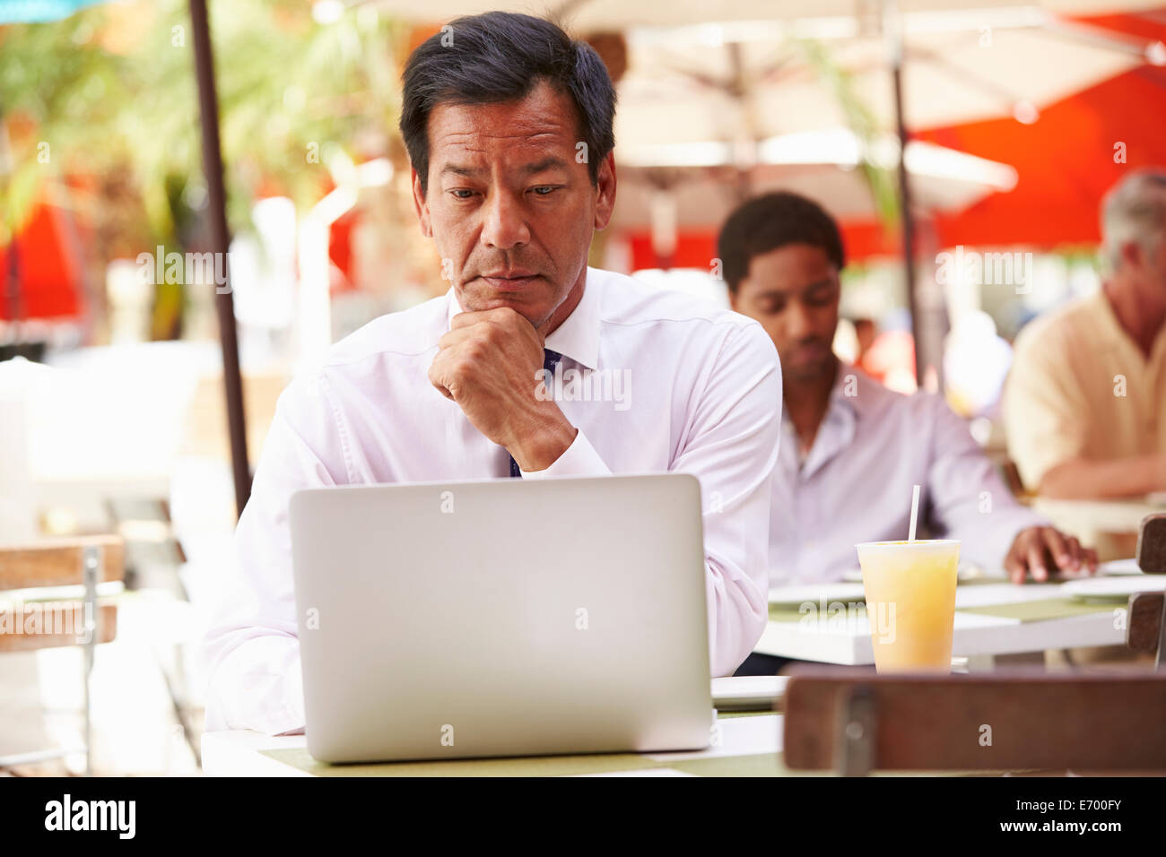Businessman Working On Laptop In Outdoor Café Stock Photo - Alamy