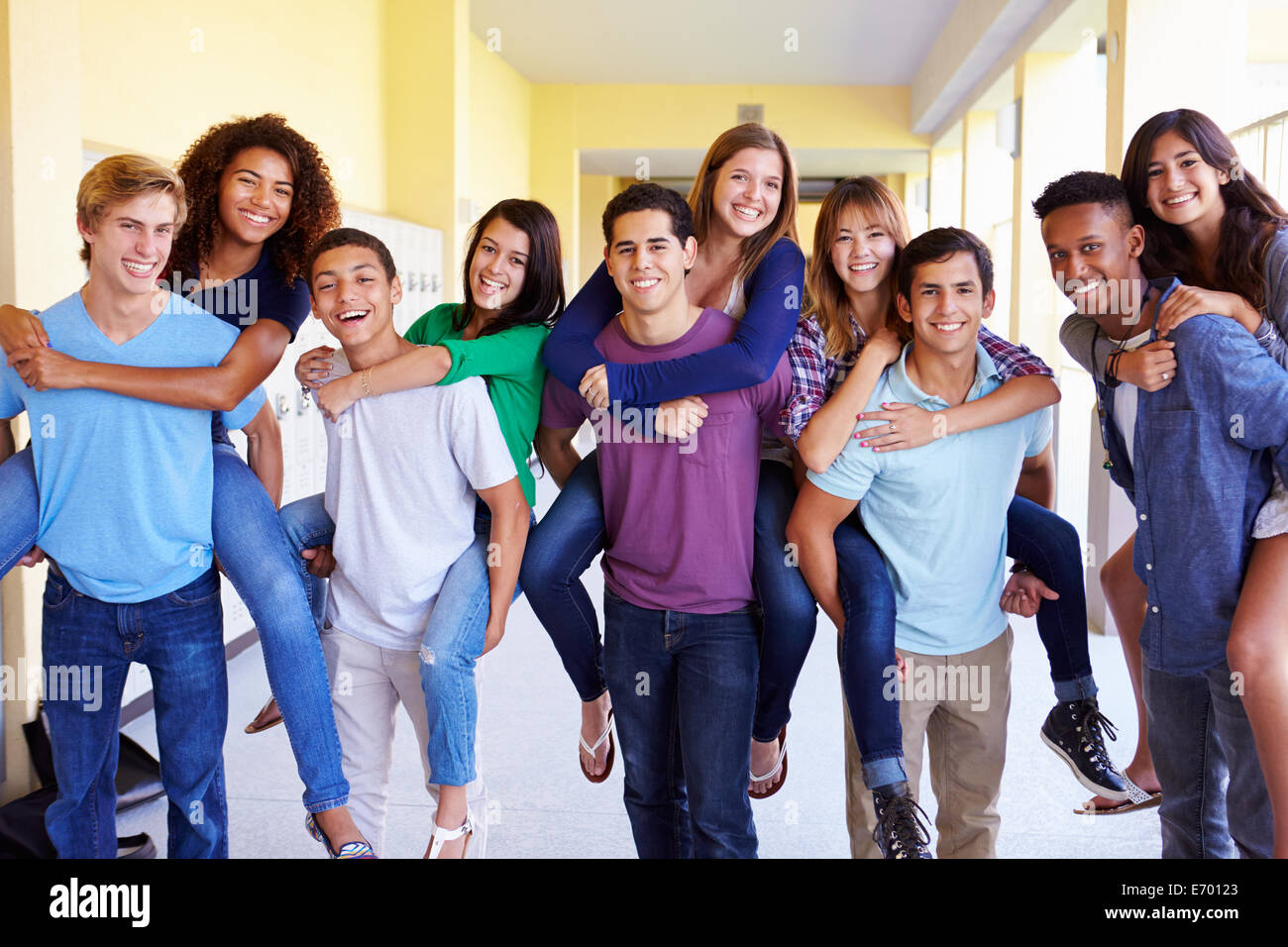 Group Of High School Students Giving Piggybacks In Corridor Stock Photo ...