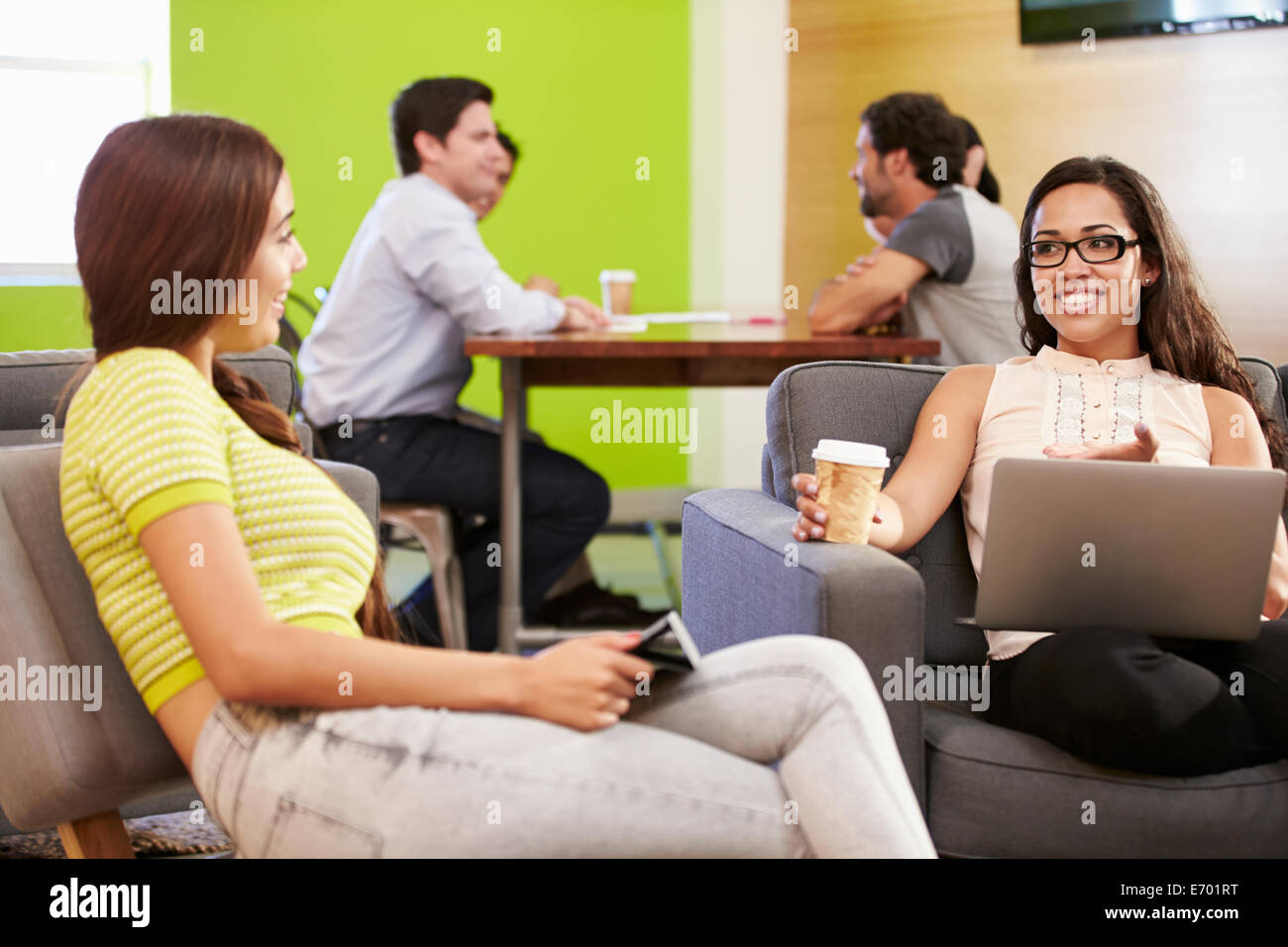 Creatives Having Informal Meeting On Sofas In Design Studio Stock Photo ...
