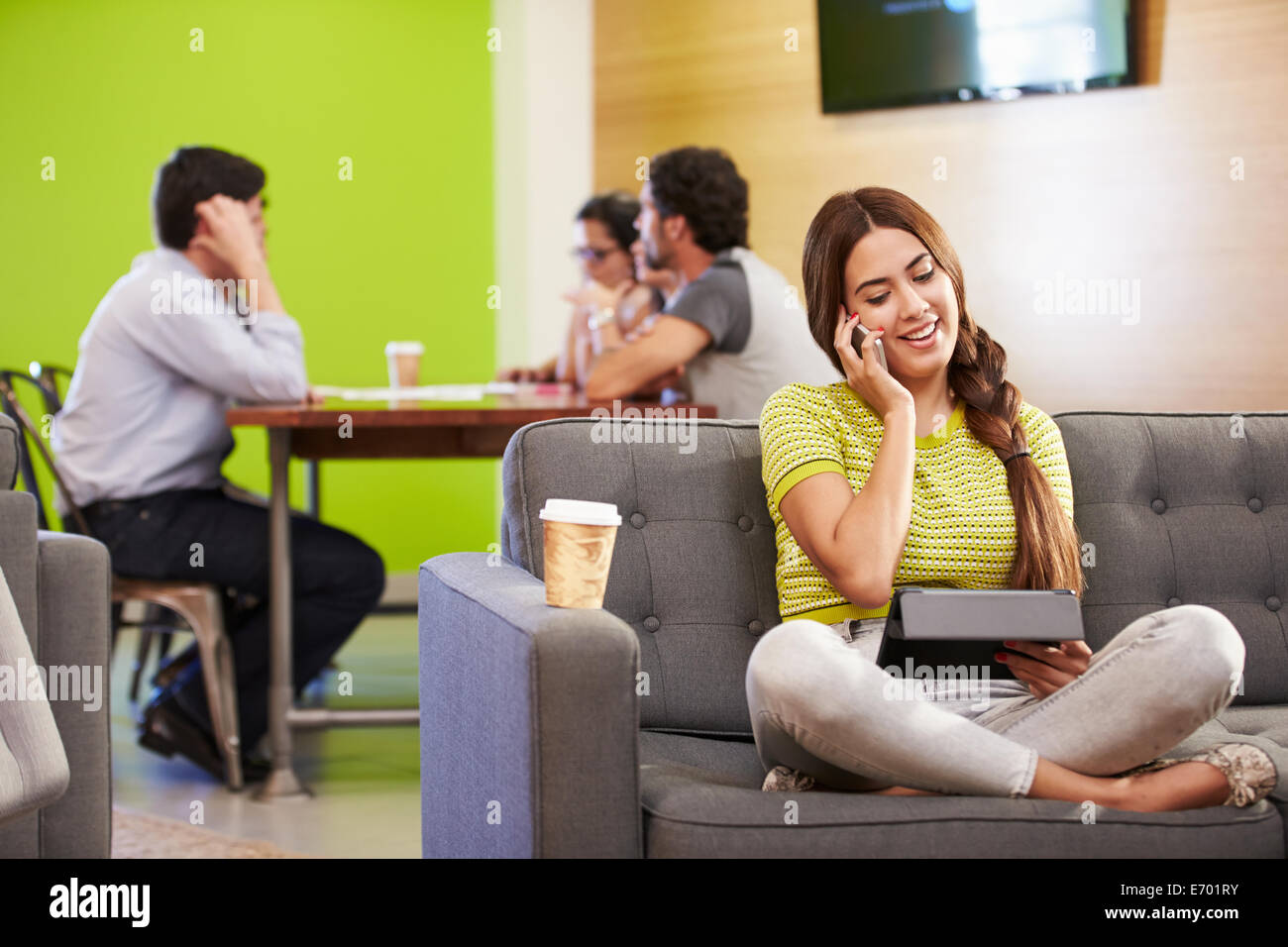 Woman Sitting On Sofa And Working In Design Studio Stock Photo - Alamy