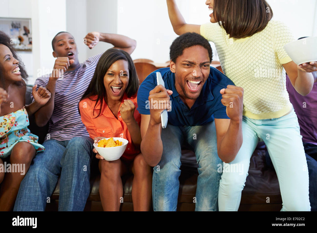 Group Of Friends Sitting On Sofa Watching TV Together Stock Photo - Alamy