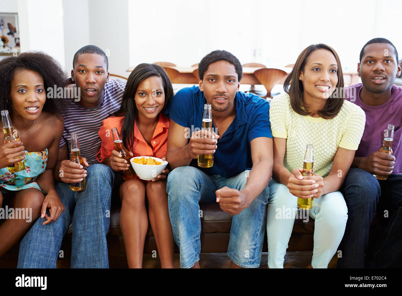Group Of Friends Sitting On Sofa Watching TV Together Stock Photo - Alamy