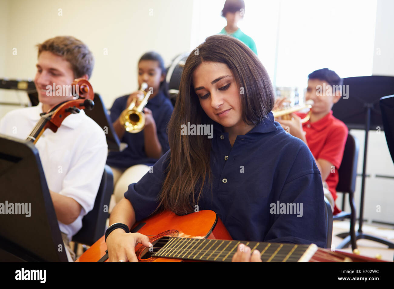 Student playing guitar in orchestra hi-res stock photography and images ...