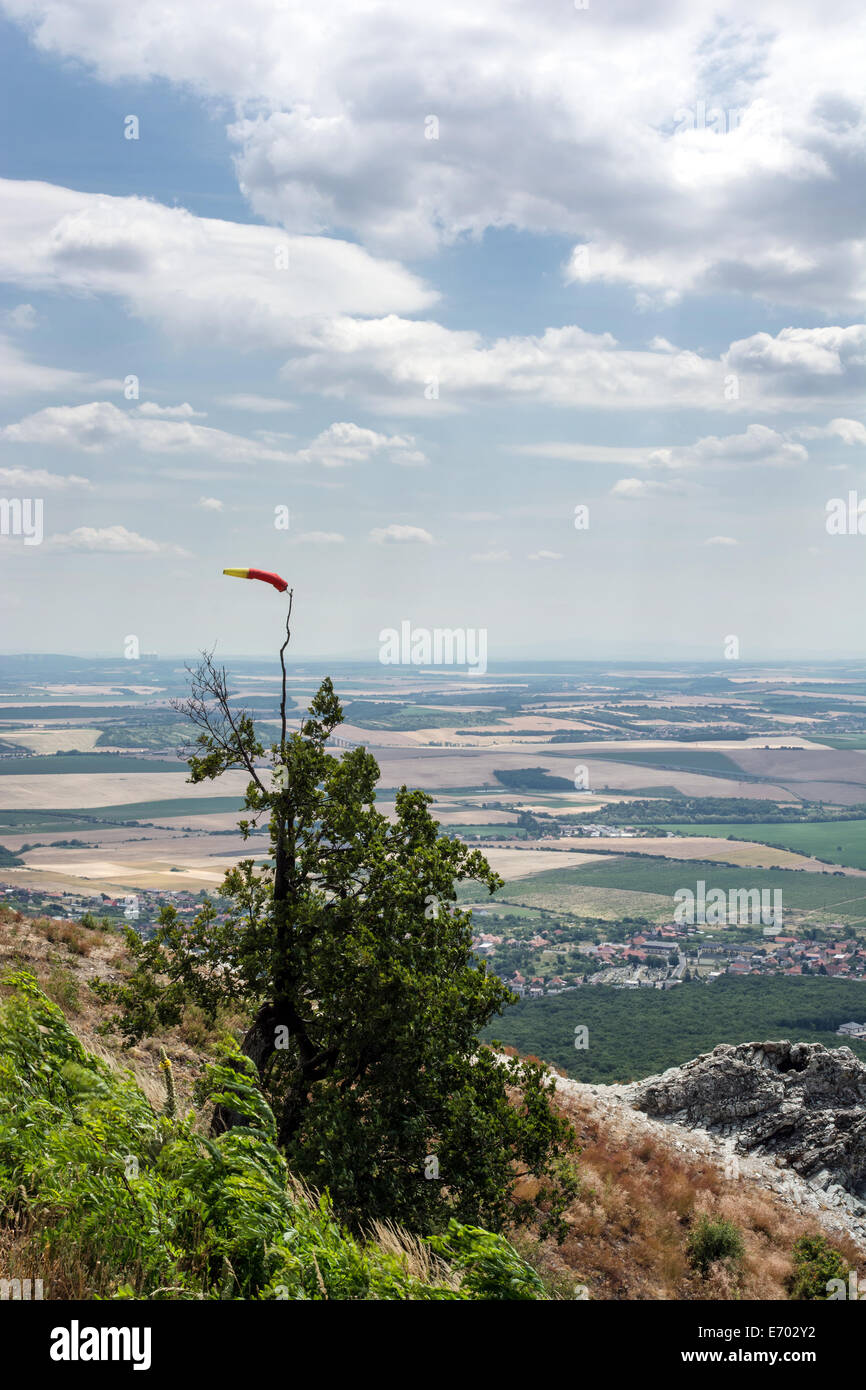 Colorful windsock on the tree. Hills, fields and cloudy sky Stock Photo ...
