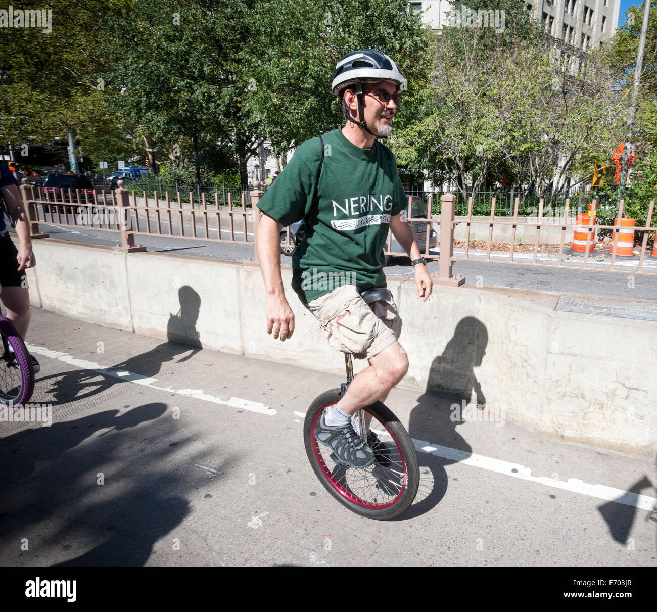 A middle-aged unicyclist rides across the Brooklyn Bridge during 13 ...