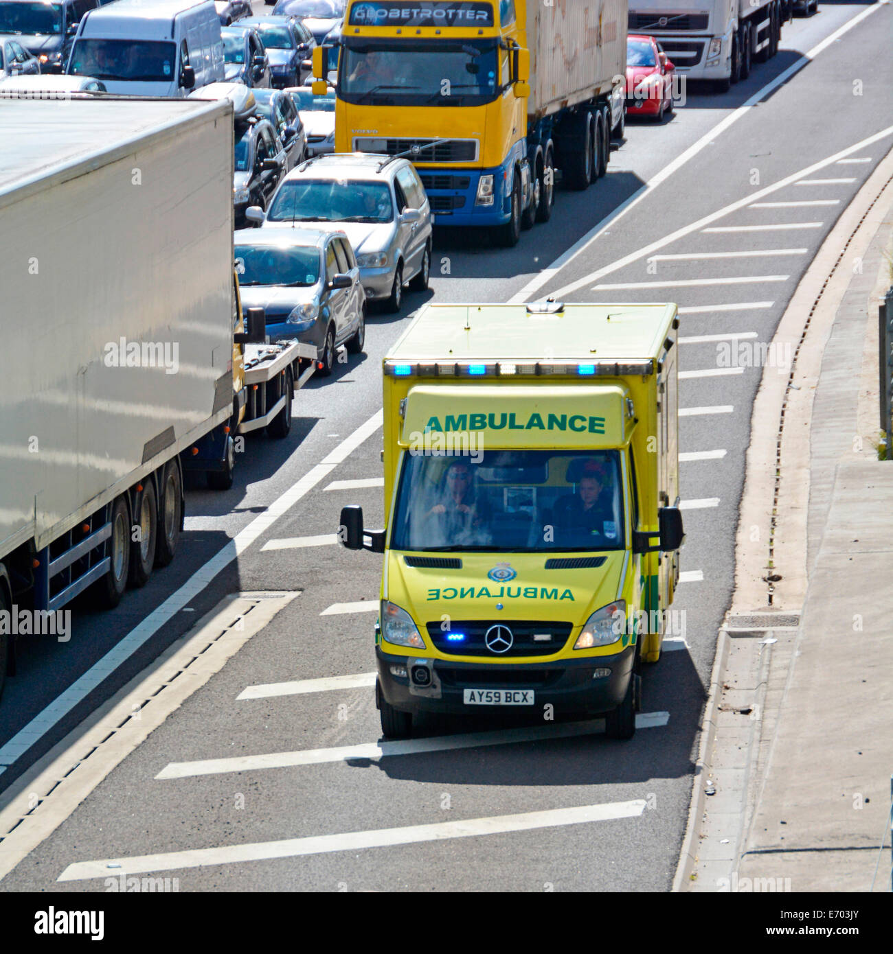 Emergency ambulance using motorway hard shoulder to reach accident ...