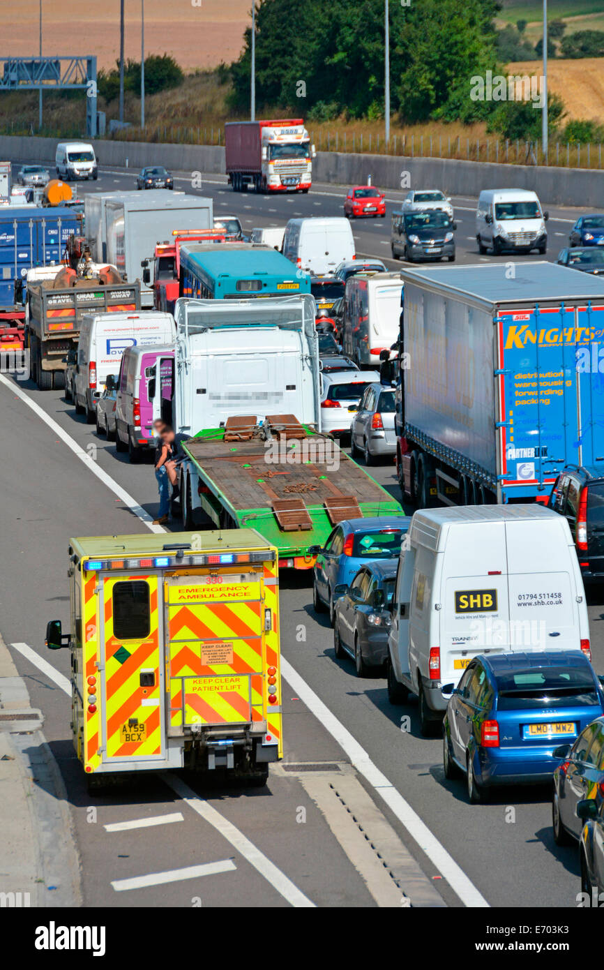 Emergency ambulance using motorway hard shoulder to reach accident ...