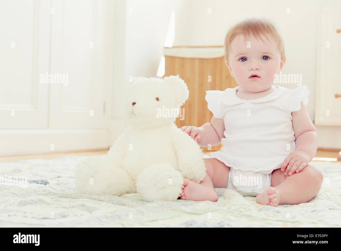 Portrait baby girl and teddy bear sitting on floor Stock Photo - Alamy