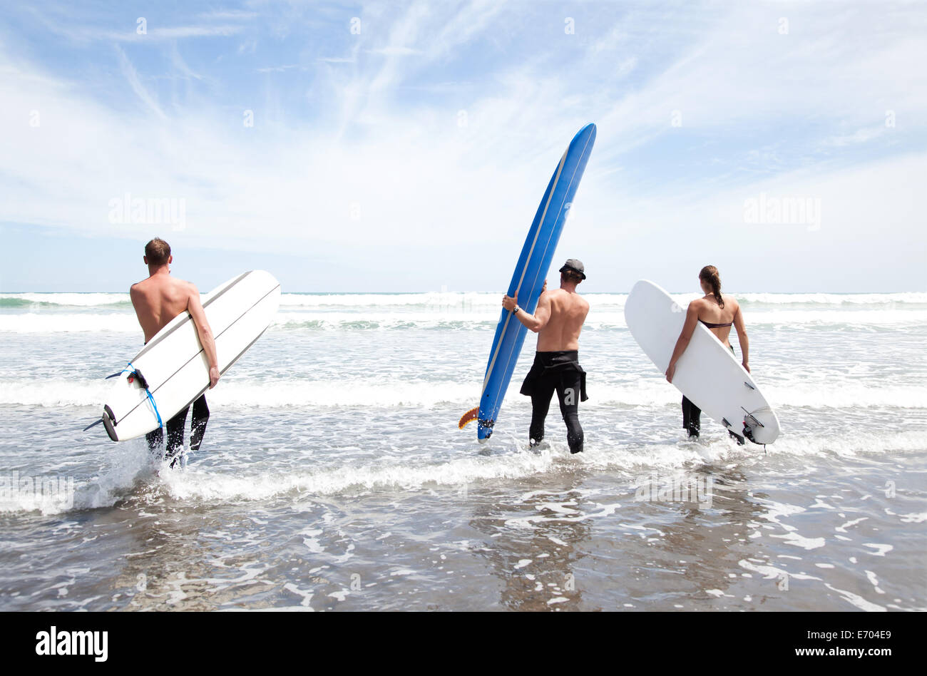 Male and female surfer friends standing in sea with surf boards Stock ...