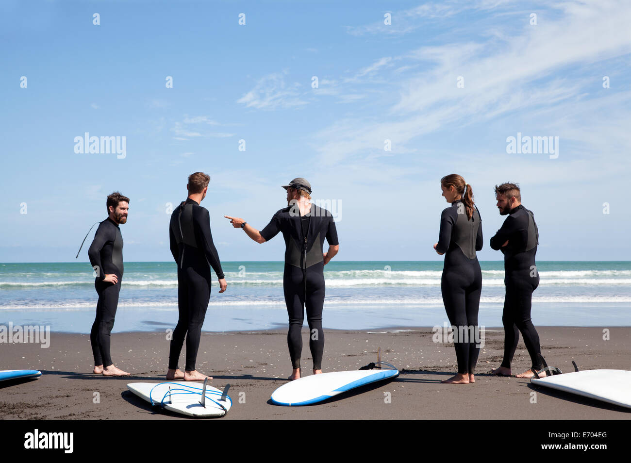 Group of male and female surfer friends chatting on beach Stock Photo ...