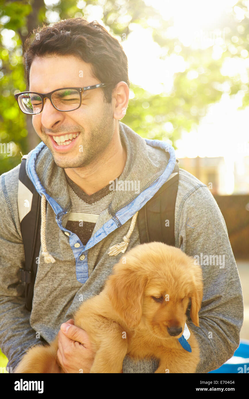 Young man holding labrador puppy Stock Photo - Alamy