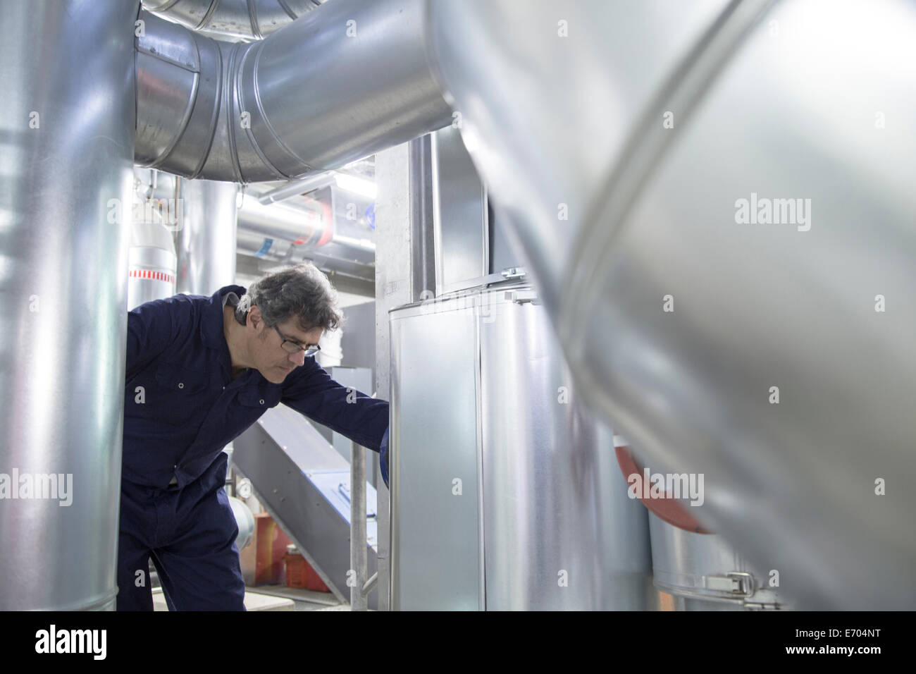 Engineer inspecting industrial piping in power station Stock Photo - Alamy