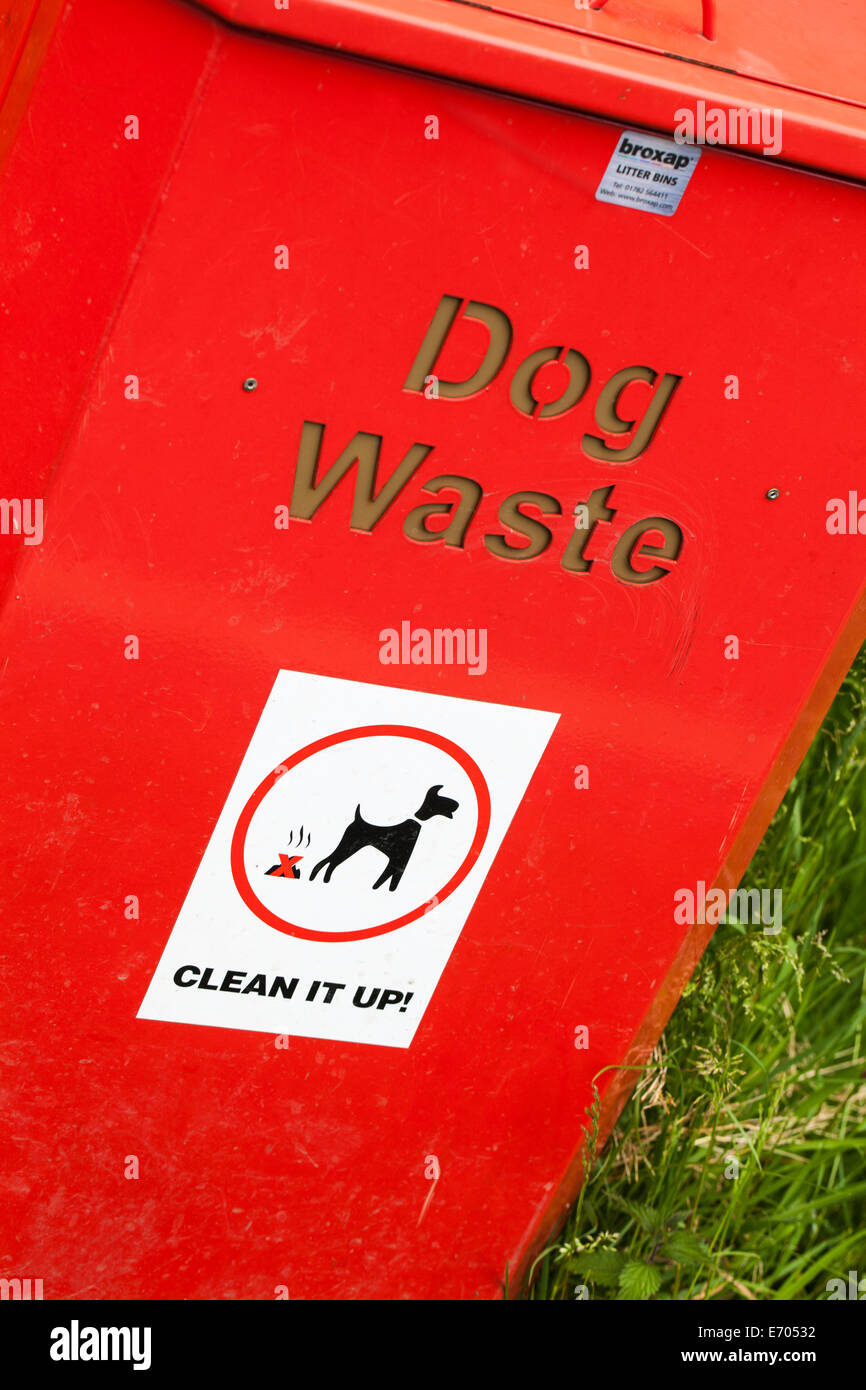 A red dog waste bin with a sign saying clean it up! on it Stock Photo ...