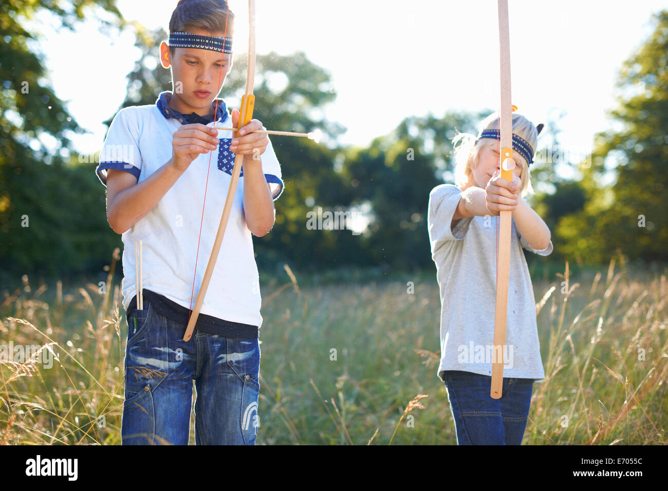 Two young boys holding bow and arrow Stock Photo - Alamy