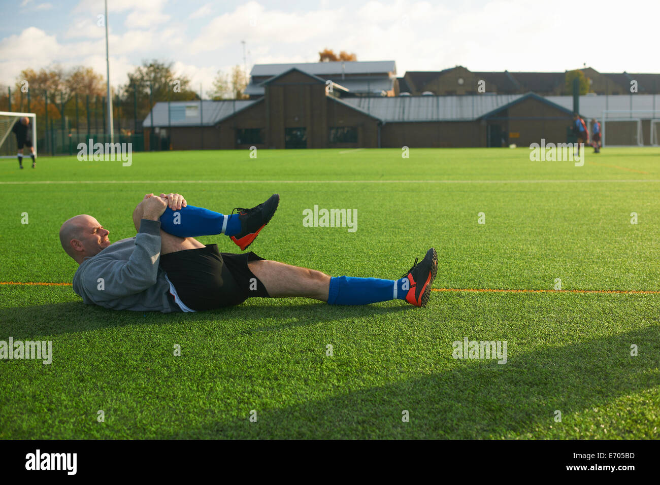 Football player stretching before game Stock Photo - Alamy