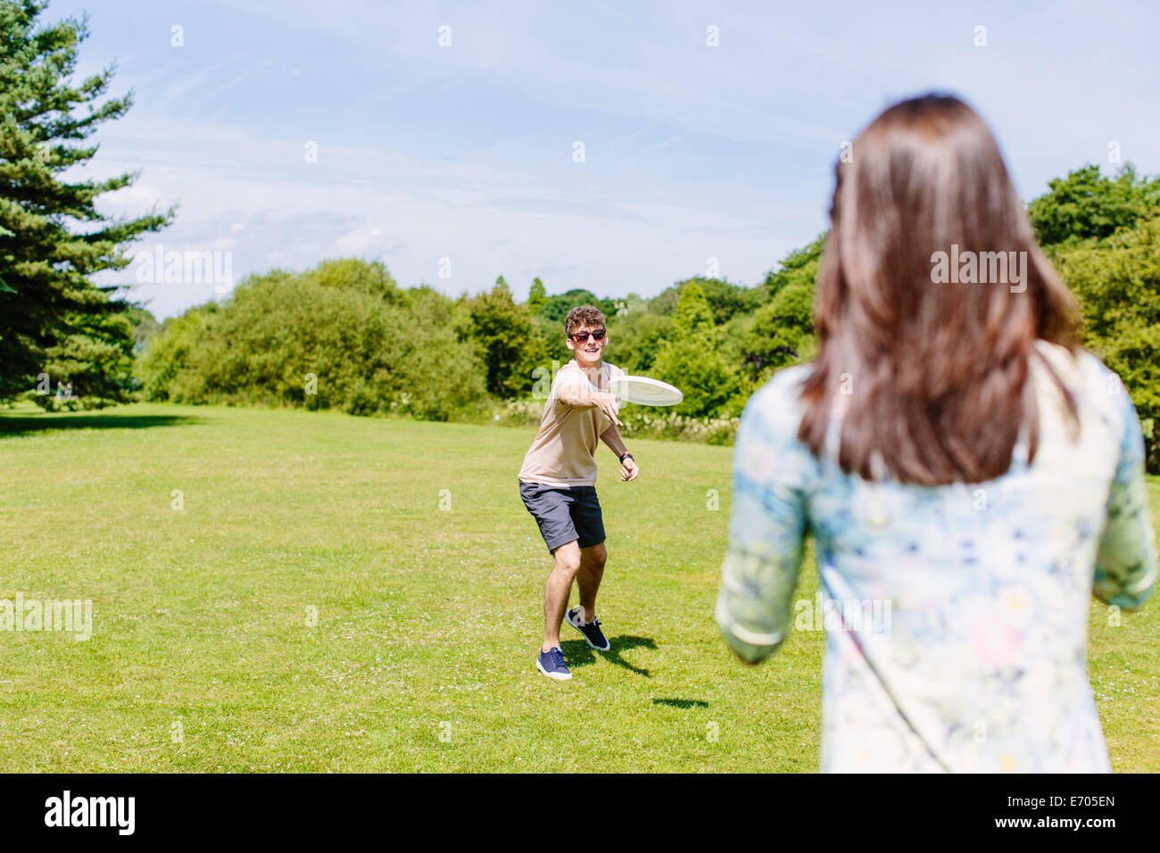 Couple playing disc game in the park Stock Photo - Alamy