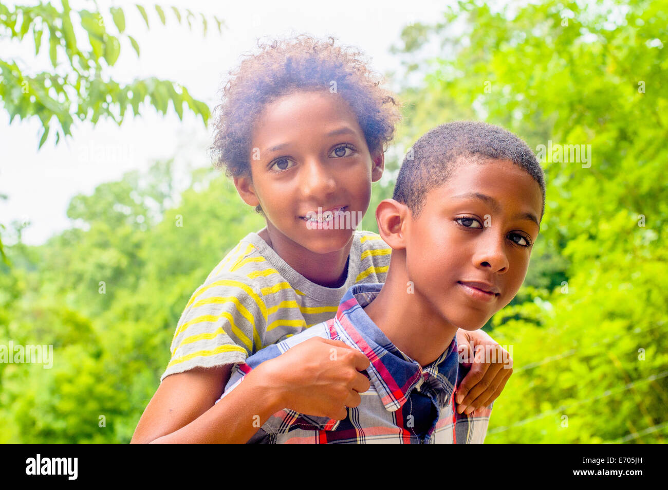 Close up of teenage boy giving friend piggyback ride Stock Photo - Alamy