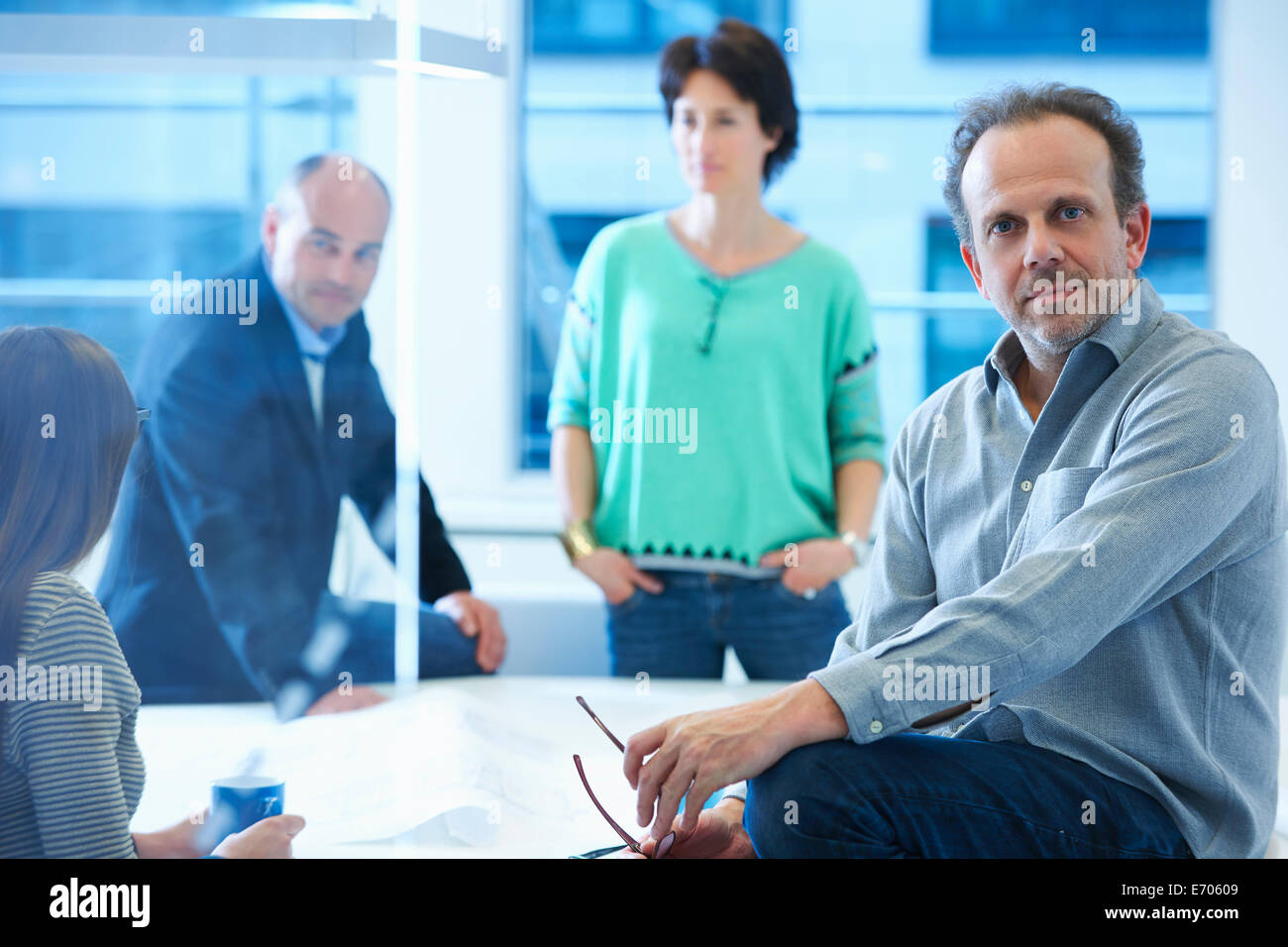 Portrait of businessman, colleagues having discussion in background ...