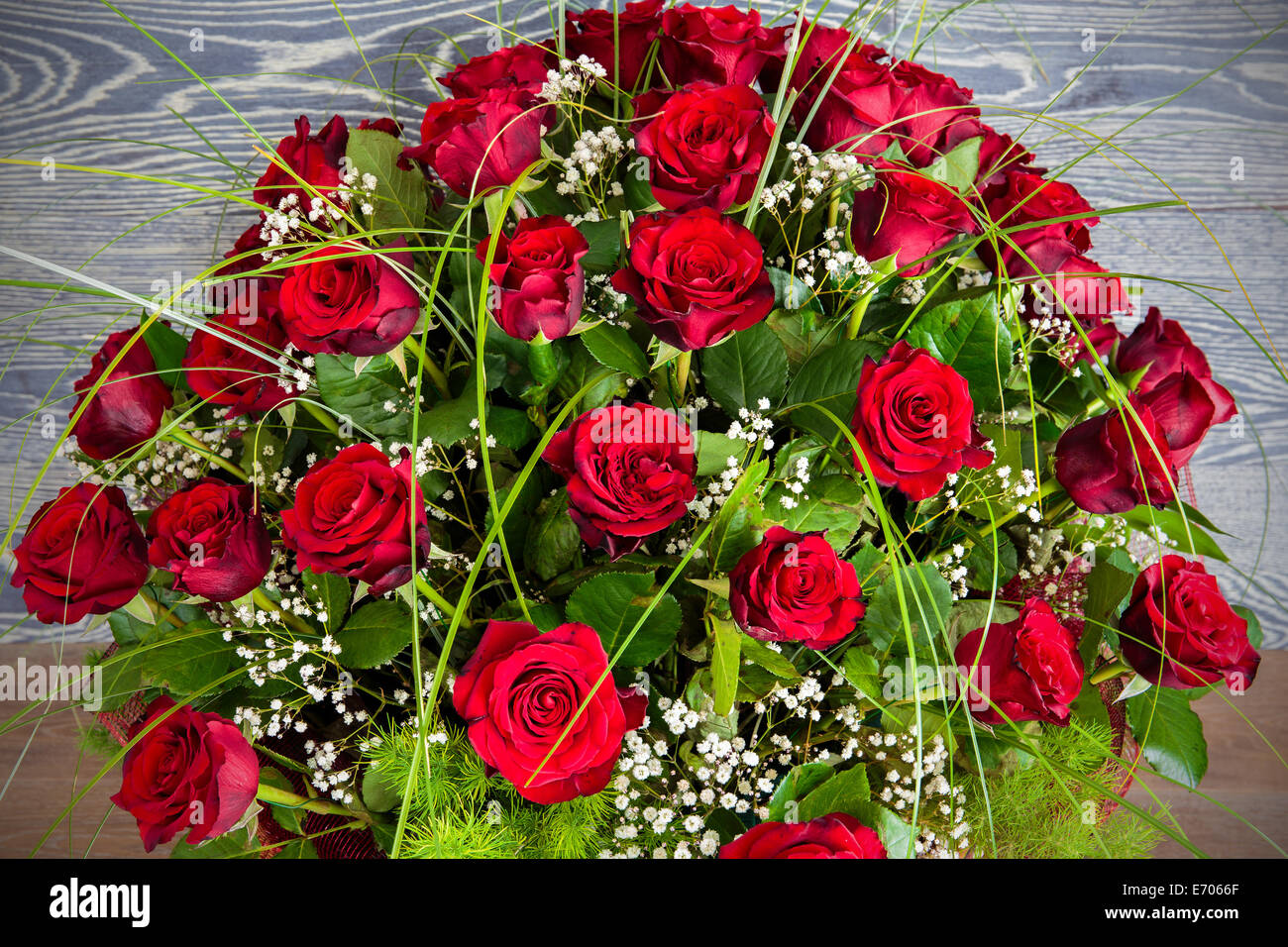 Beautiful red roses bouquet against wooden background Stock Photo - Alamy