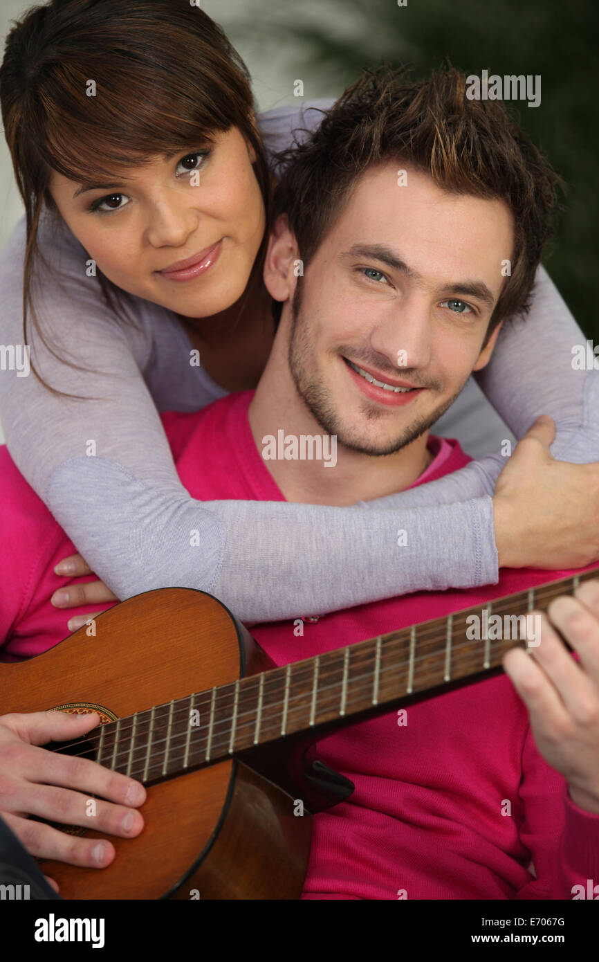 Girl hugging boy with guitar Stock Photo - Alamy