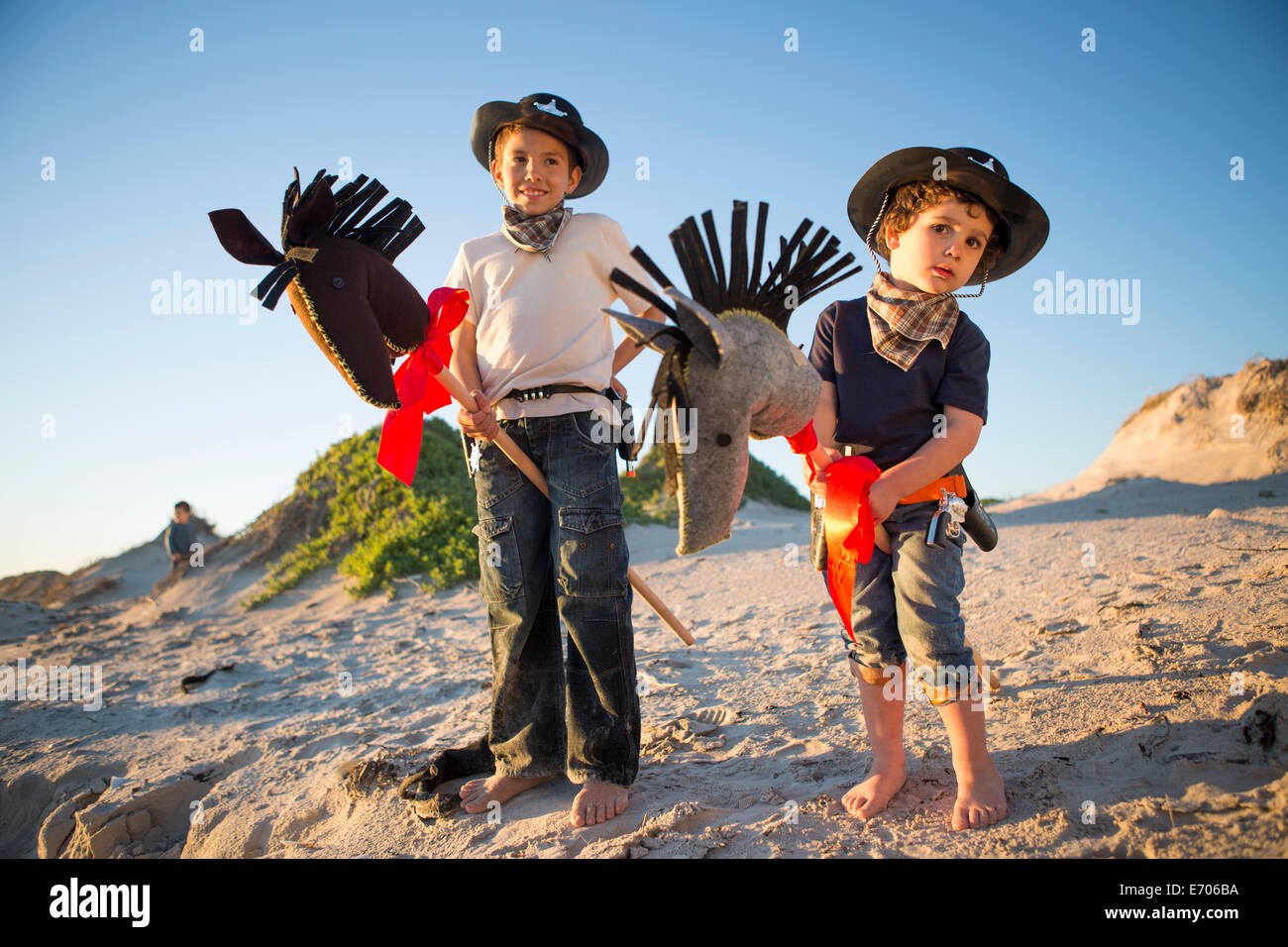 Two brothers dressed as cowboy's with hobby horse's Stock Photo - Alamy