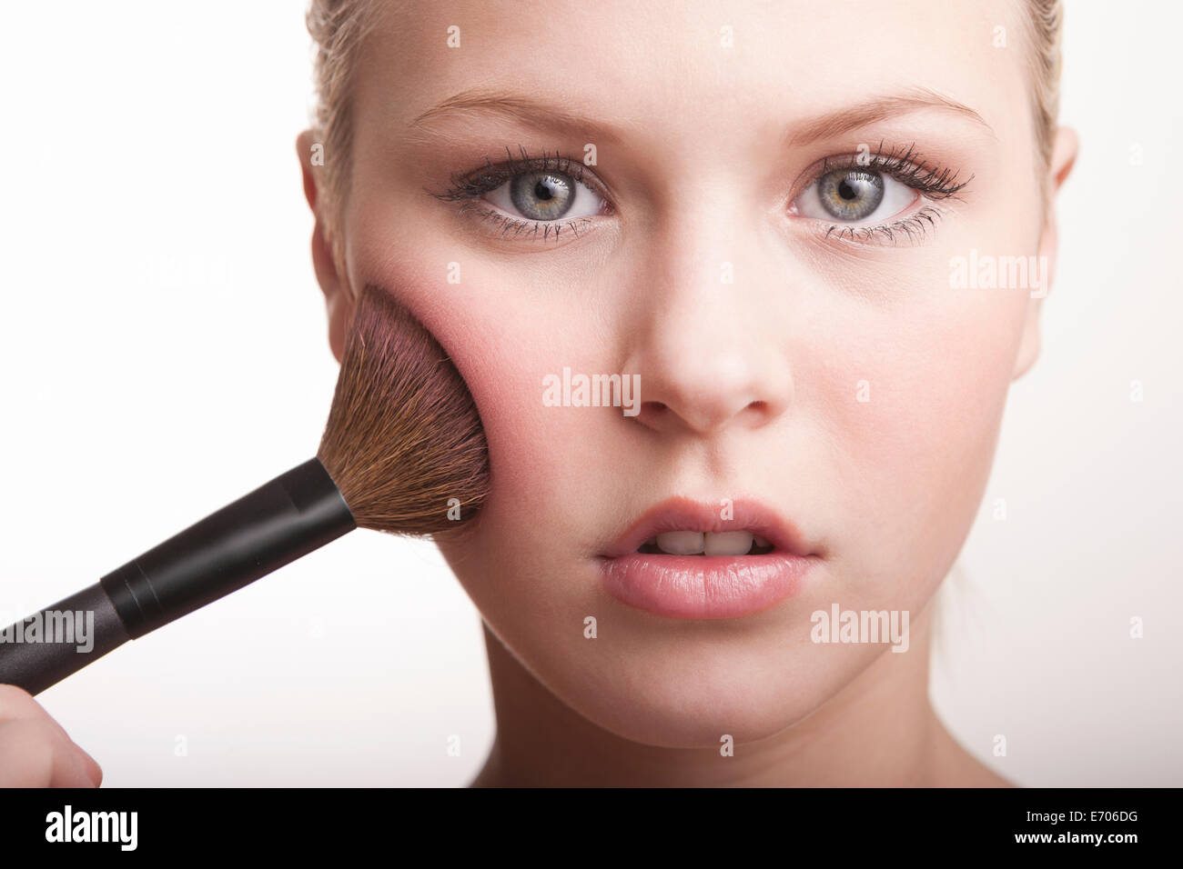 Teenage girl applying blusher Stock Photo - Alamy
