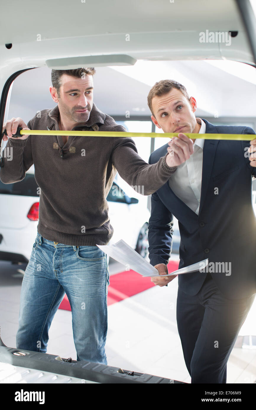 Customer and salesman measuring van interior in car dealership Stock ...