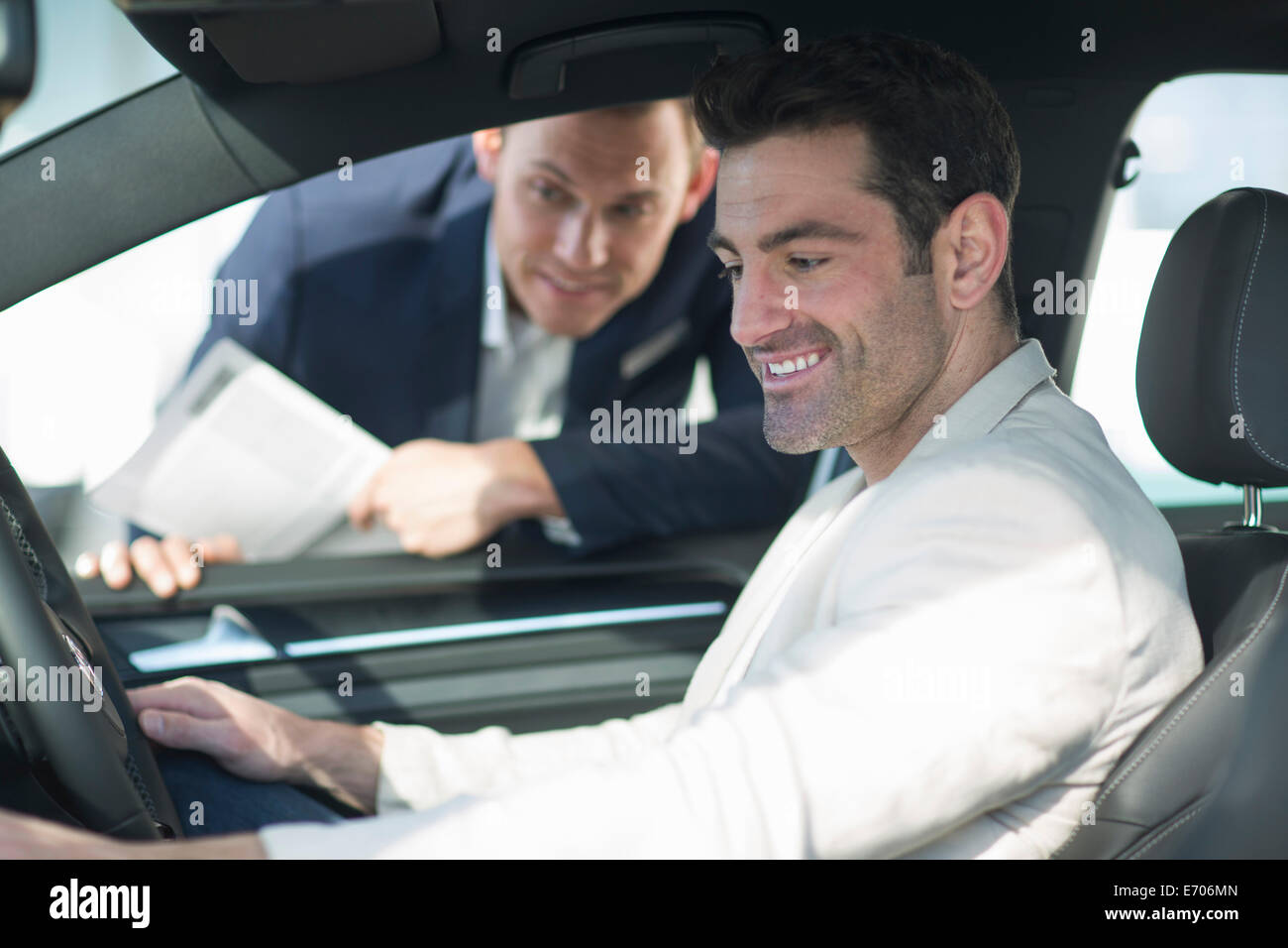 Customer trying out new car in car dealership Stock Photo - Alamy