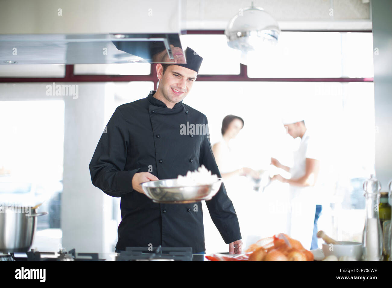 Male chef carrying frying pan in commercial kitchen Stock Photo - Alamy