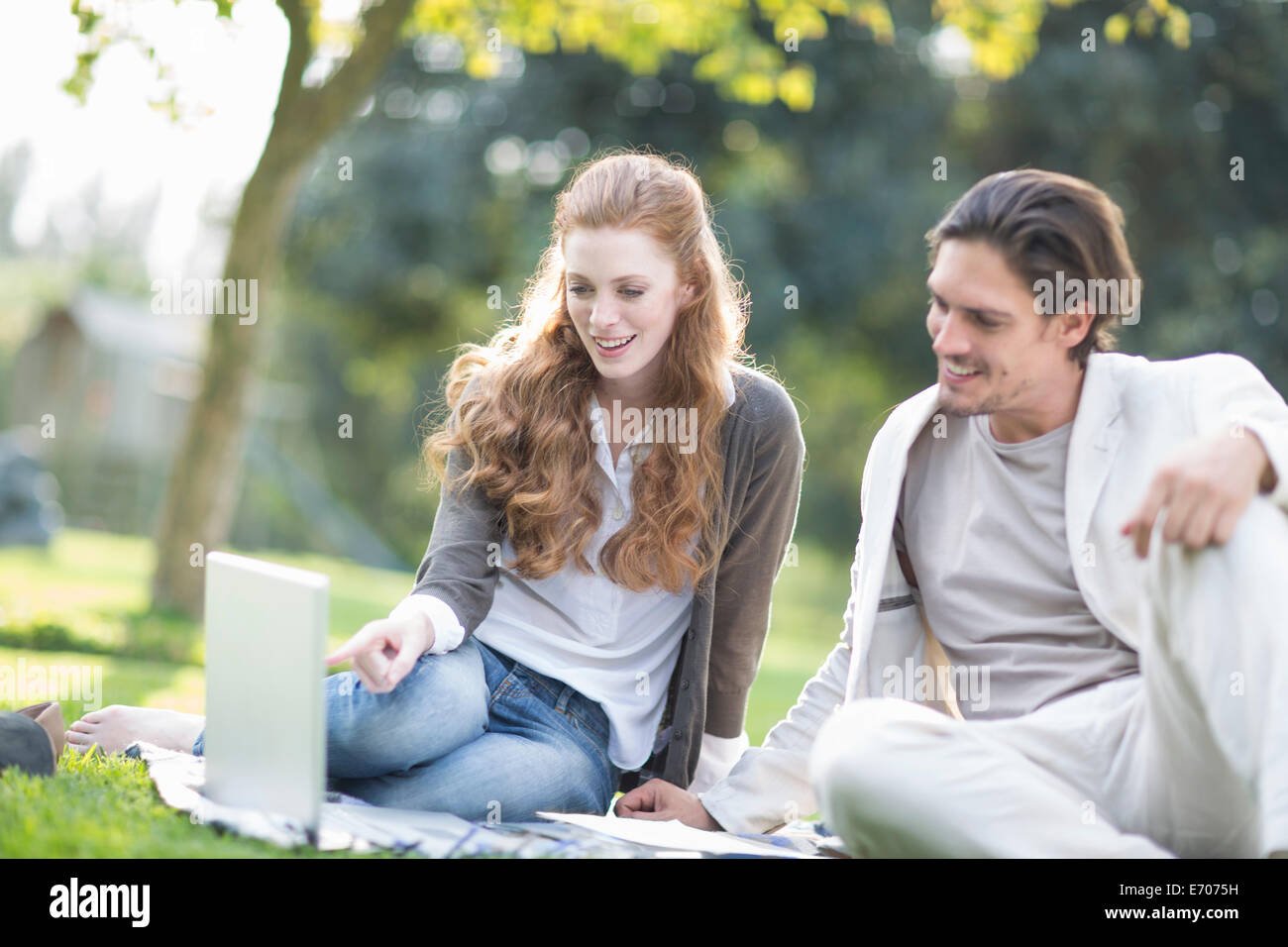 Businessman and female colleague using laptop in park Stock Photo - Alamy
