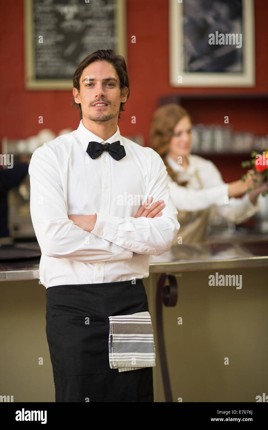 Portrait of waiter with arms folded in restaurant Stock Photo - Alamy