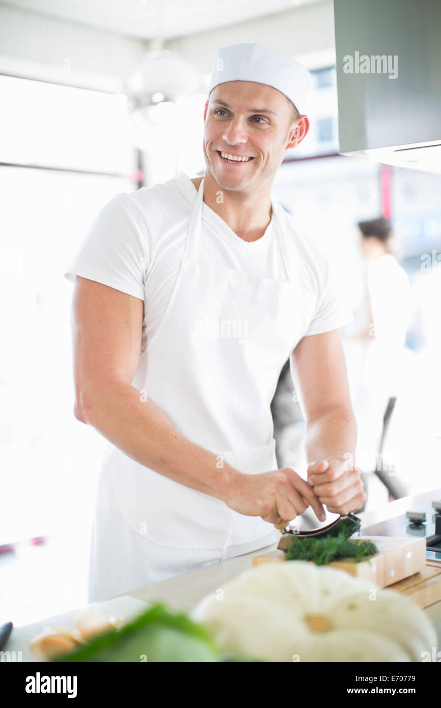 Male chef mixing chopping herbs in commercial kitchen Stock Photo - Alamy