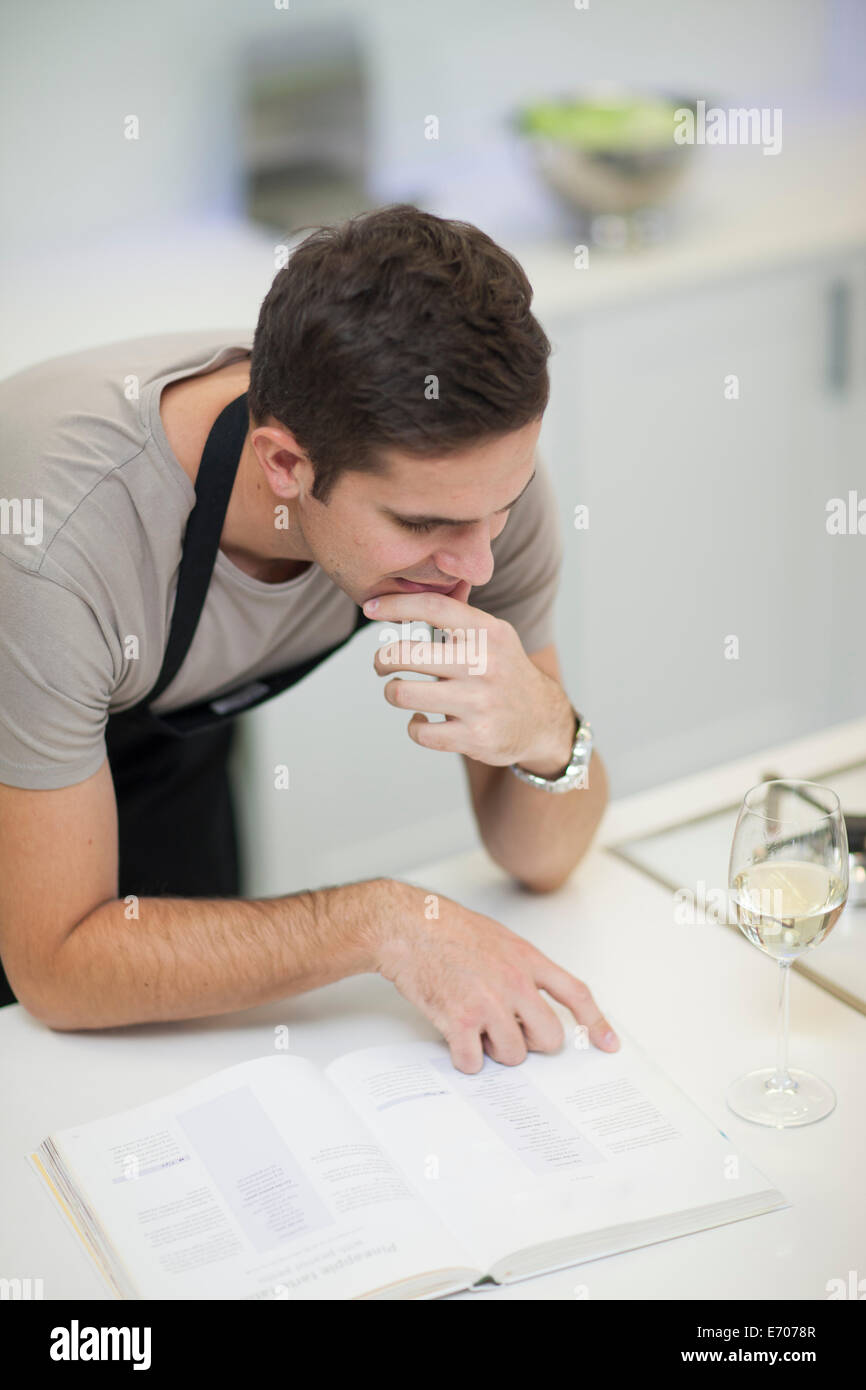 Man reading recipe in cookbook Stock Photo - Alamy