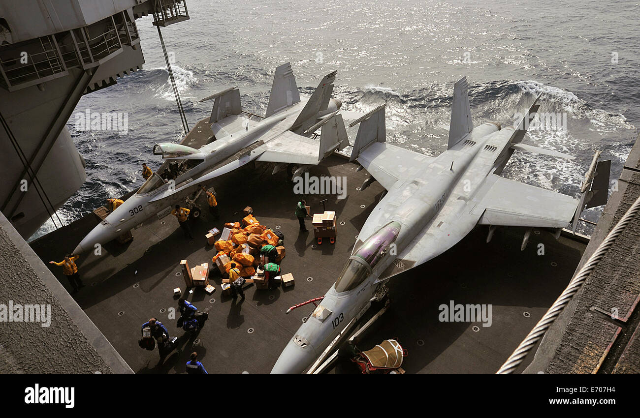 A US Navy sailors lower aircraft and mail on an elevator aboard the ...