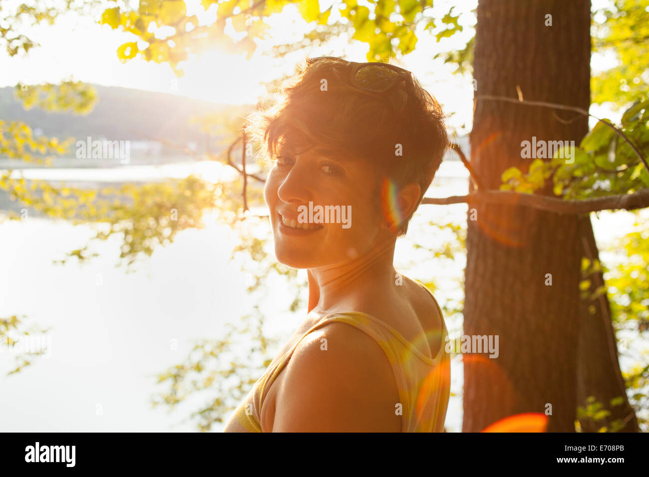 Portrait of mid adult woman by lakeside at sunset Stock Photo - Alamy