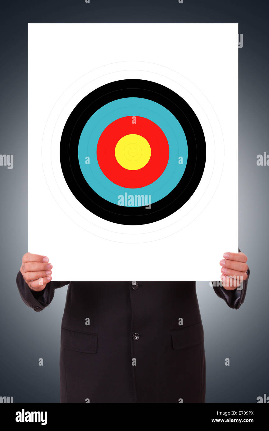 Businessman hand holding white poster with colorful target on dark ...