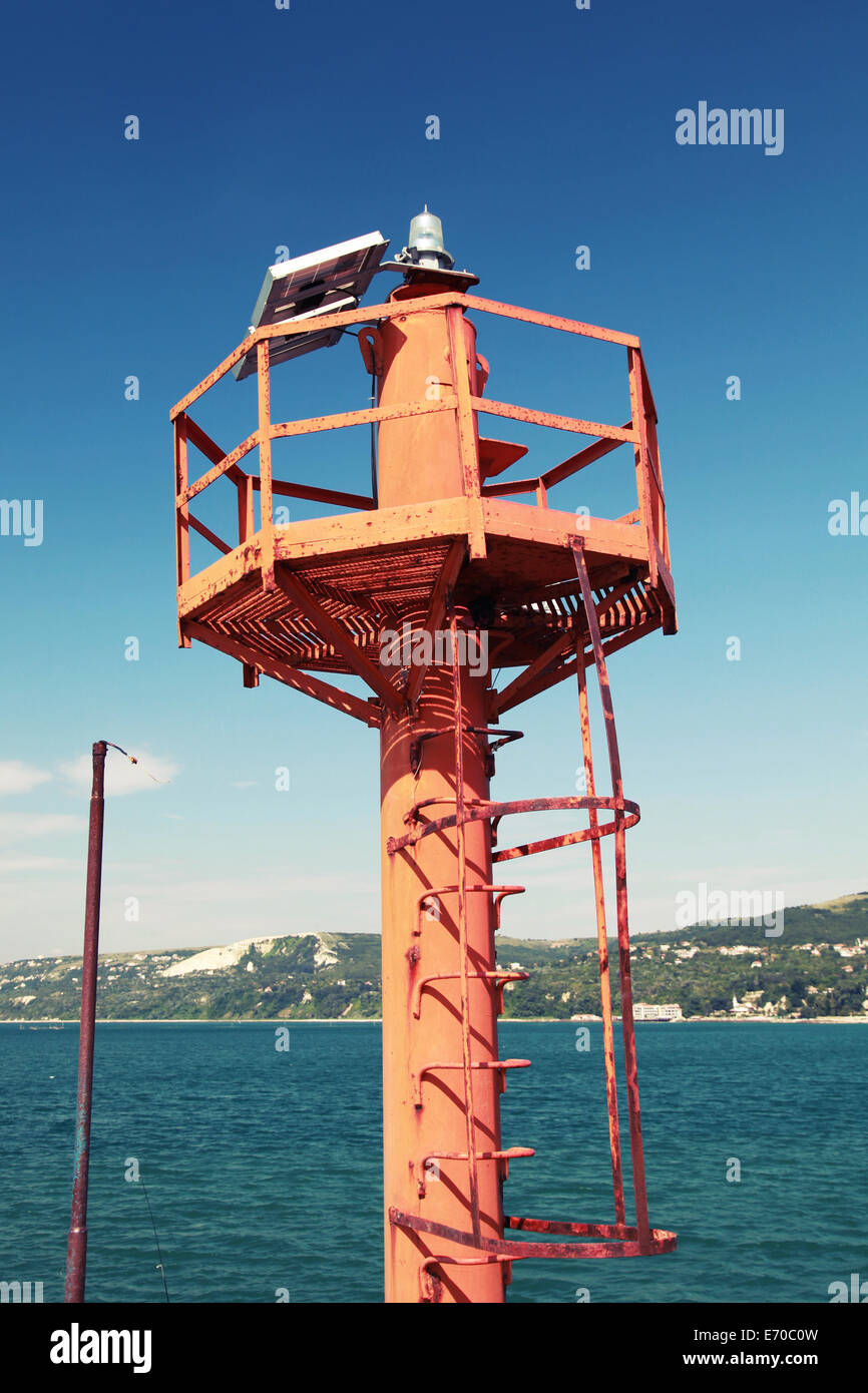 Small red lighthouse pole on the coast of Black Sea Stock Photo - Alamy