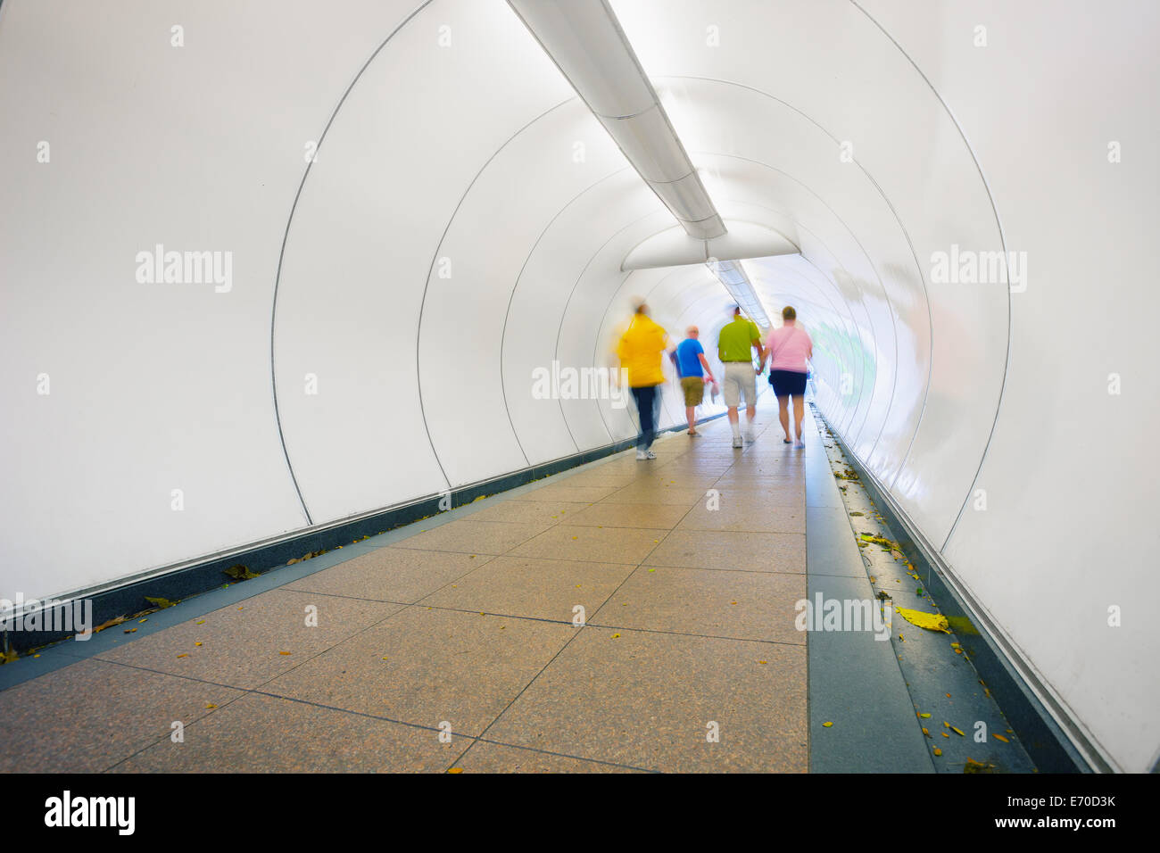 People go through the underpass. Abstract photo from the center of ...