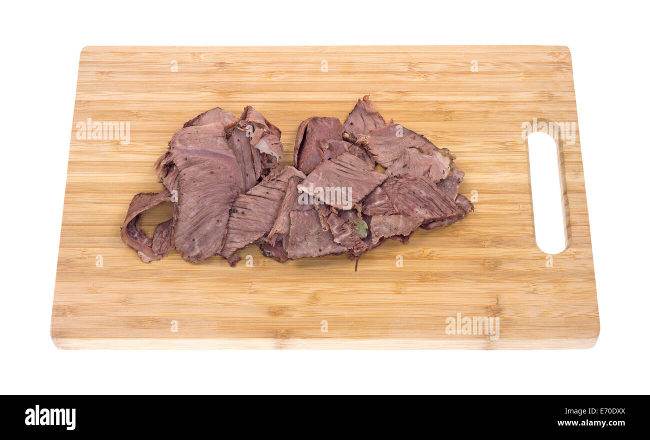 A portion of thin sliced leftover chuck roast on a wood cutting board ...