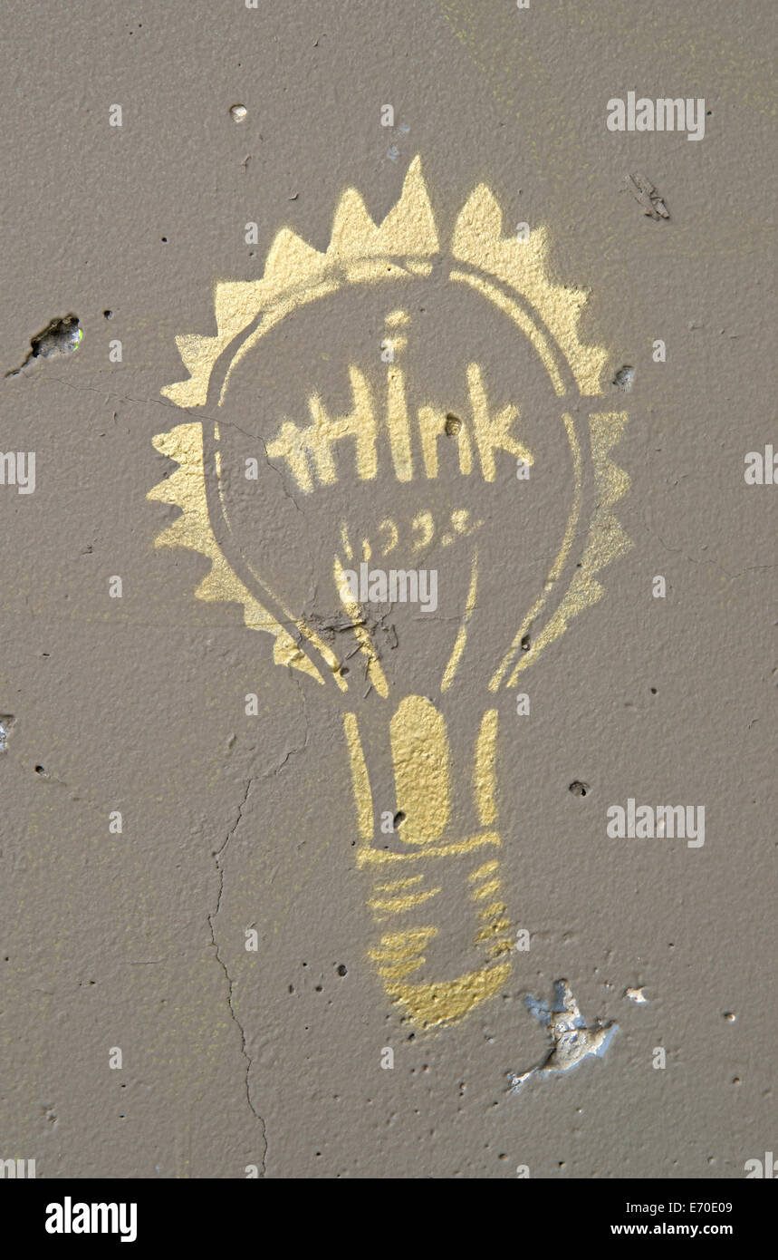 A graffiti of a light bulb with think in the center on a concrete wall ...