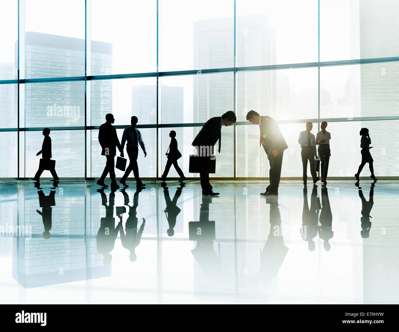 Two Business Men Bowing To Each Other Indoors Amongst The Other ...