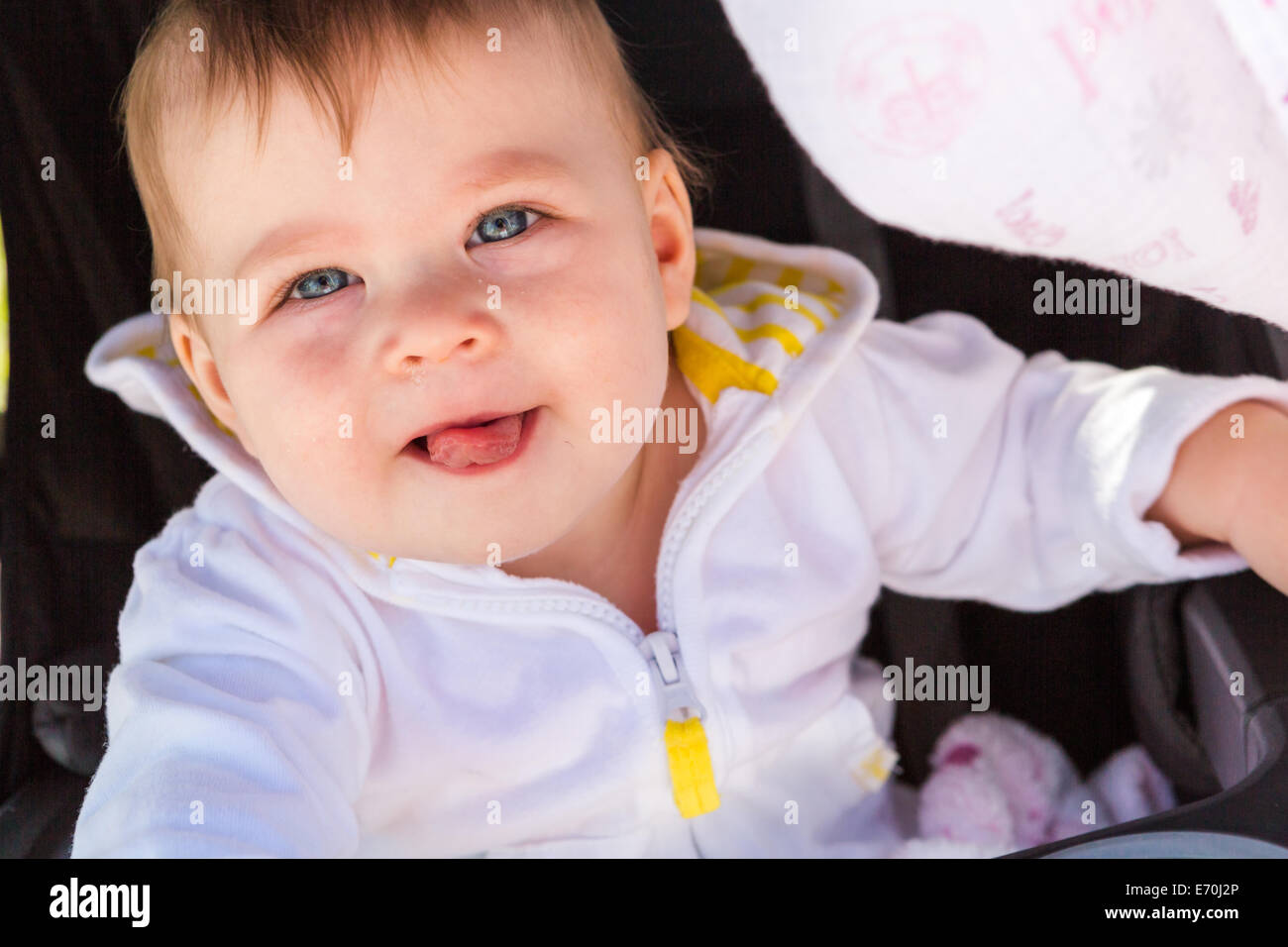 Cute baby girl sitting in the striller Stock Photo - Alamy