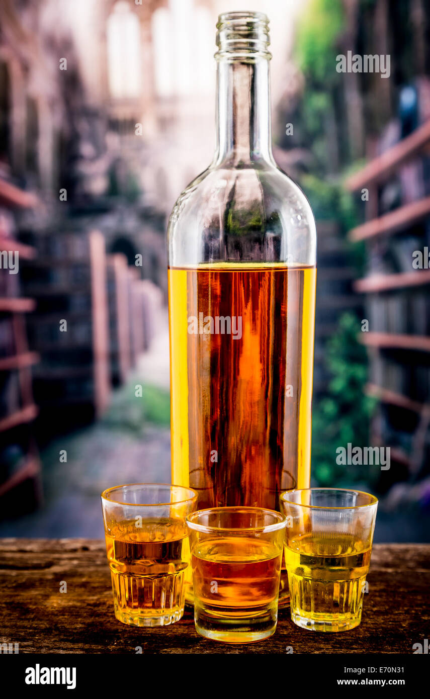 Bottle and glass shots with yellow liqour resembling whiskey, rum ...