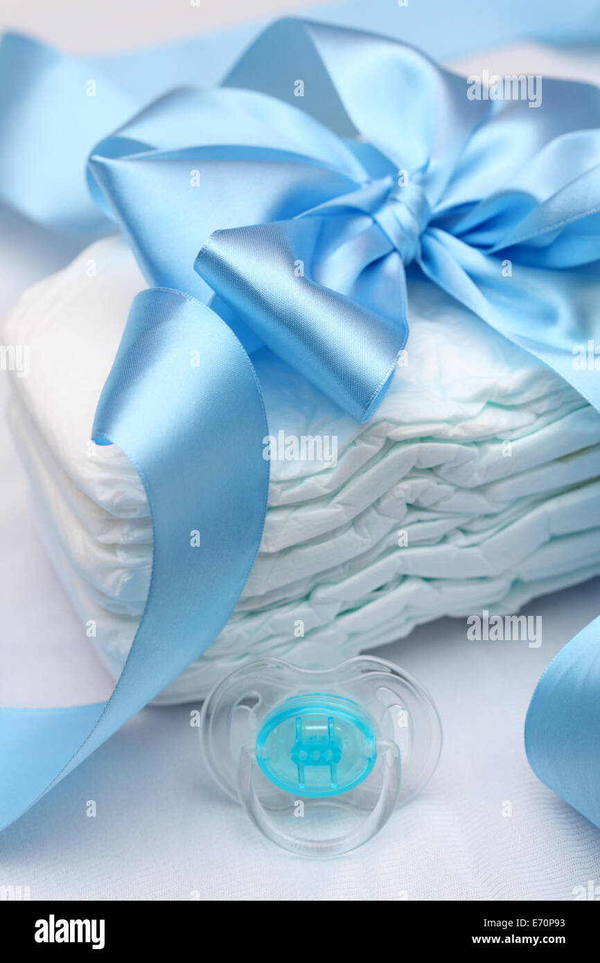 Pacifier and diapers with blue bow. Close-up Stock Photo - Alamy